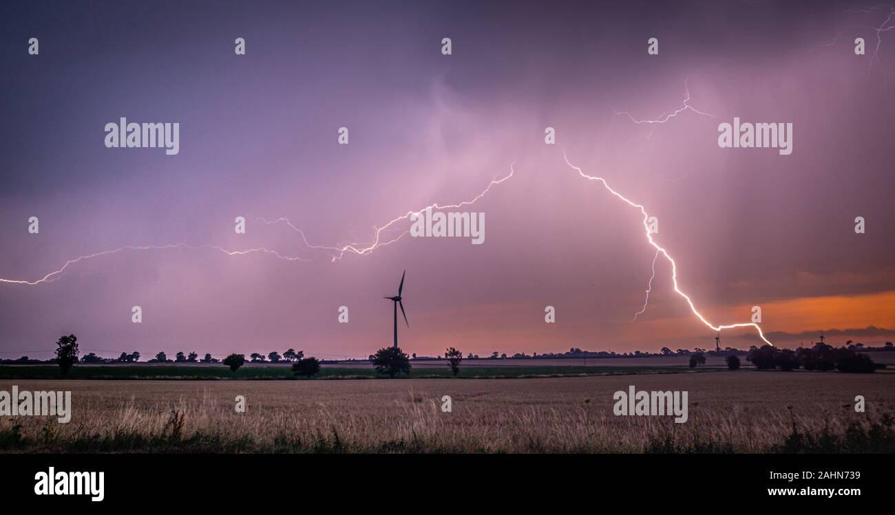 Severe lightning at sunrise pictured around a wind turbine Stock Photo ...