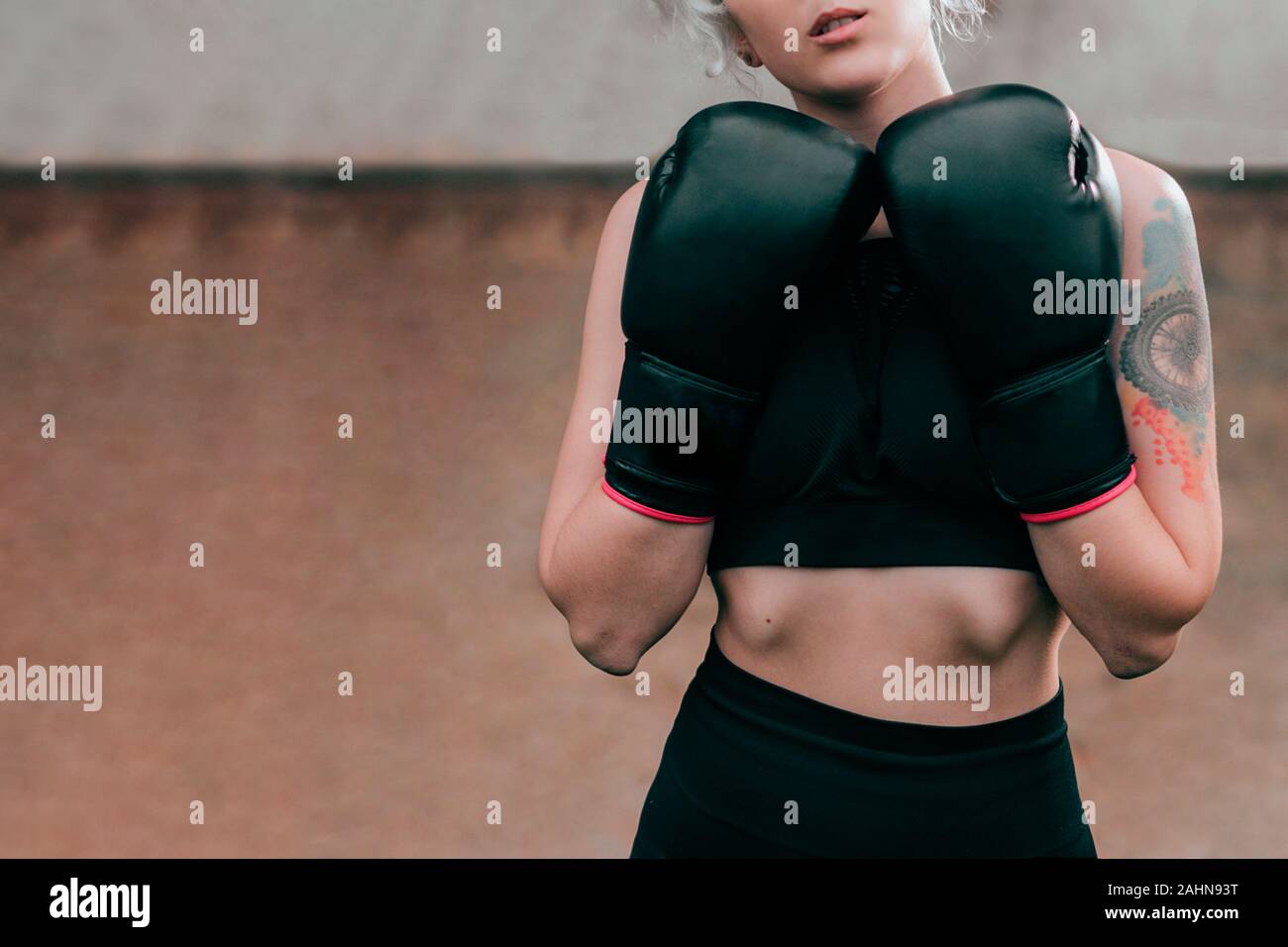 Professional female boxer with braid standing outside with boxing ...