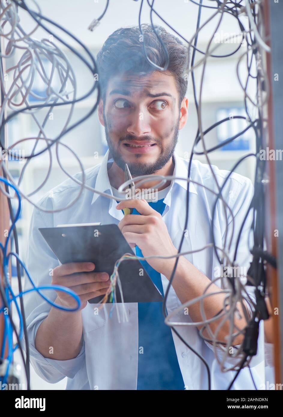 The electrician trying to untangle wires in repair concept Stock Photo ...