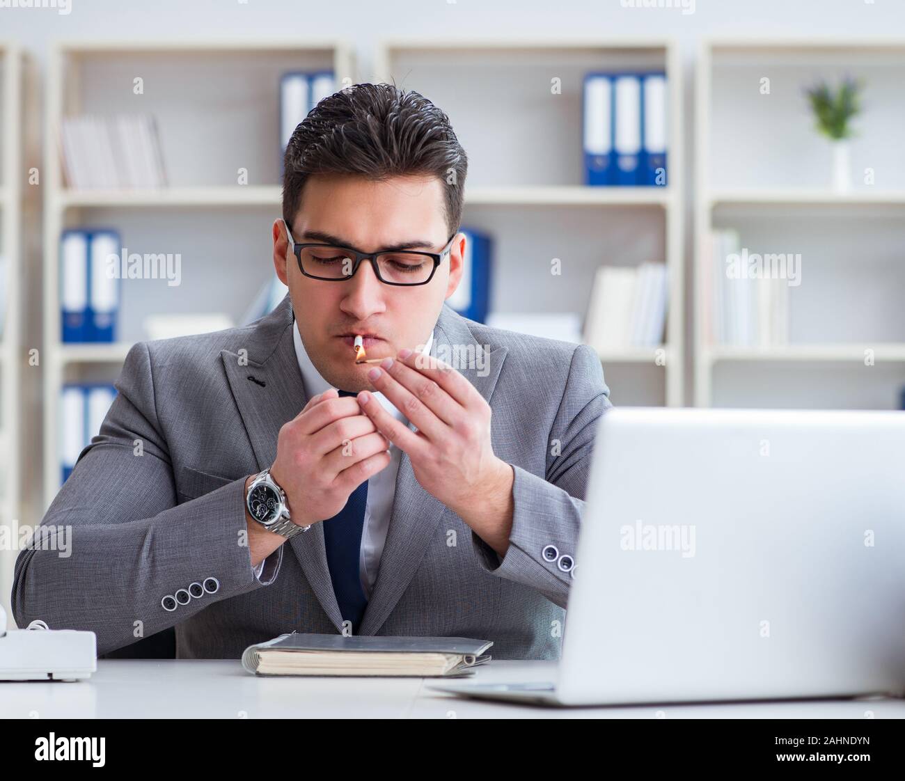 The businessman smoking in office at work Stock Photo - Alamy