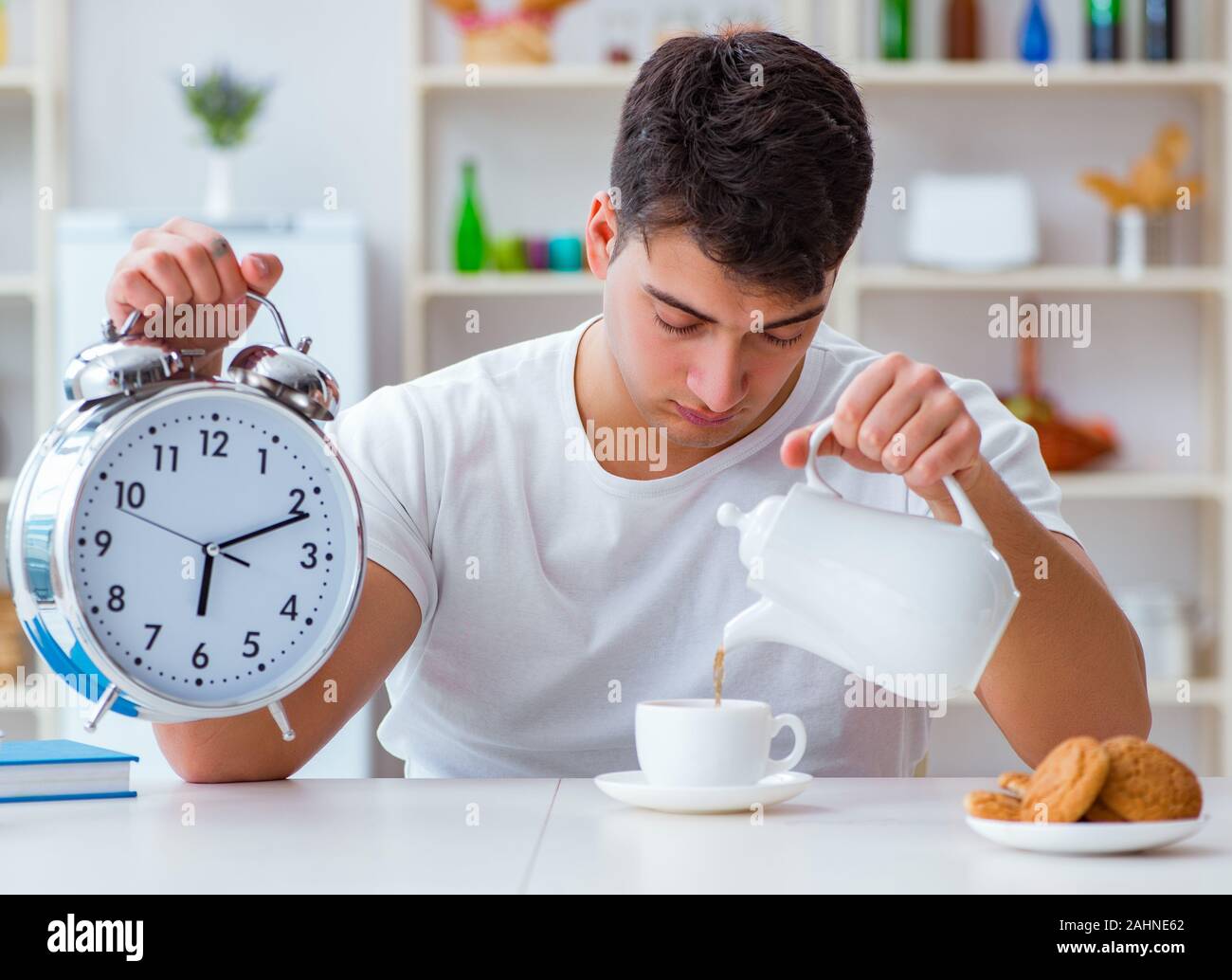 The man with alarm clock falling asleep at breakfast Stock Photo - Alamy