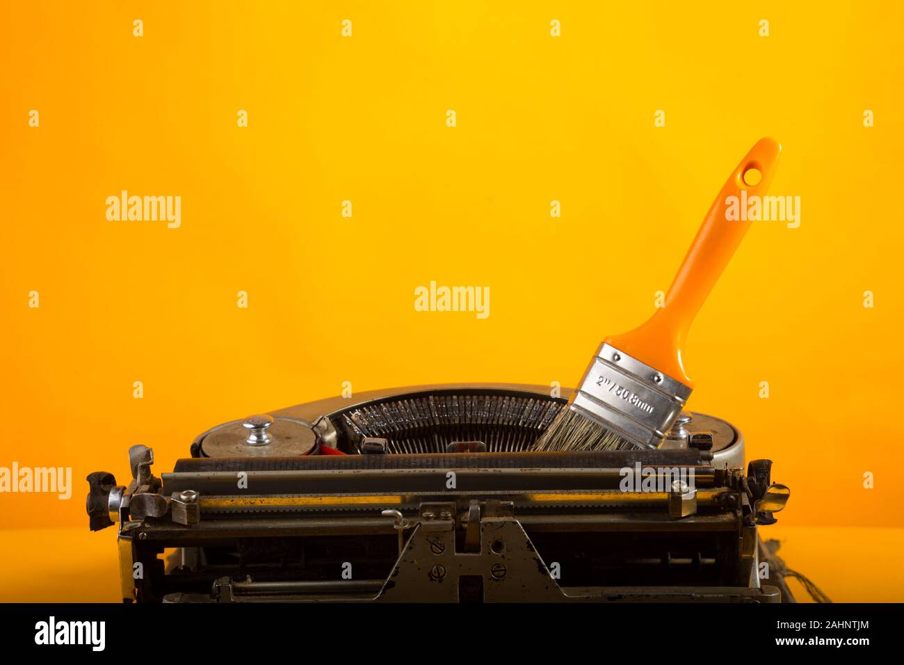 Cleaning an old vintage typewriter with a brush Stock Photo - Alamy