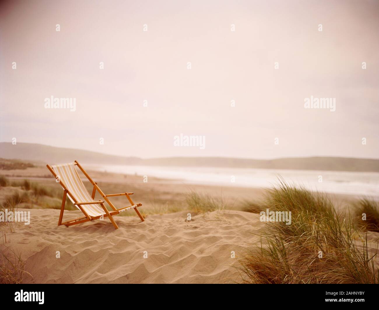Side view of a folding chair on an isolated beach Stock Photo - Alamy