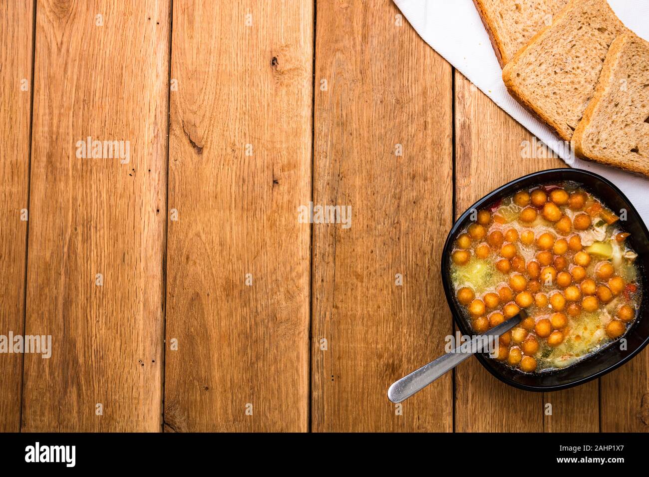 Chicken soup with sour cream, wholegrain toast on white napkin and ...