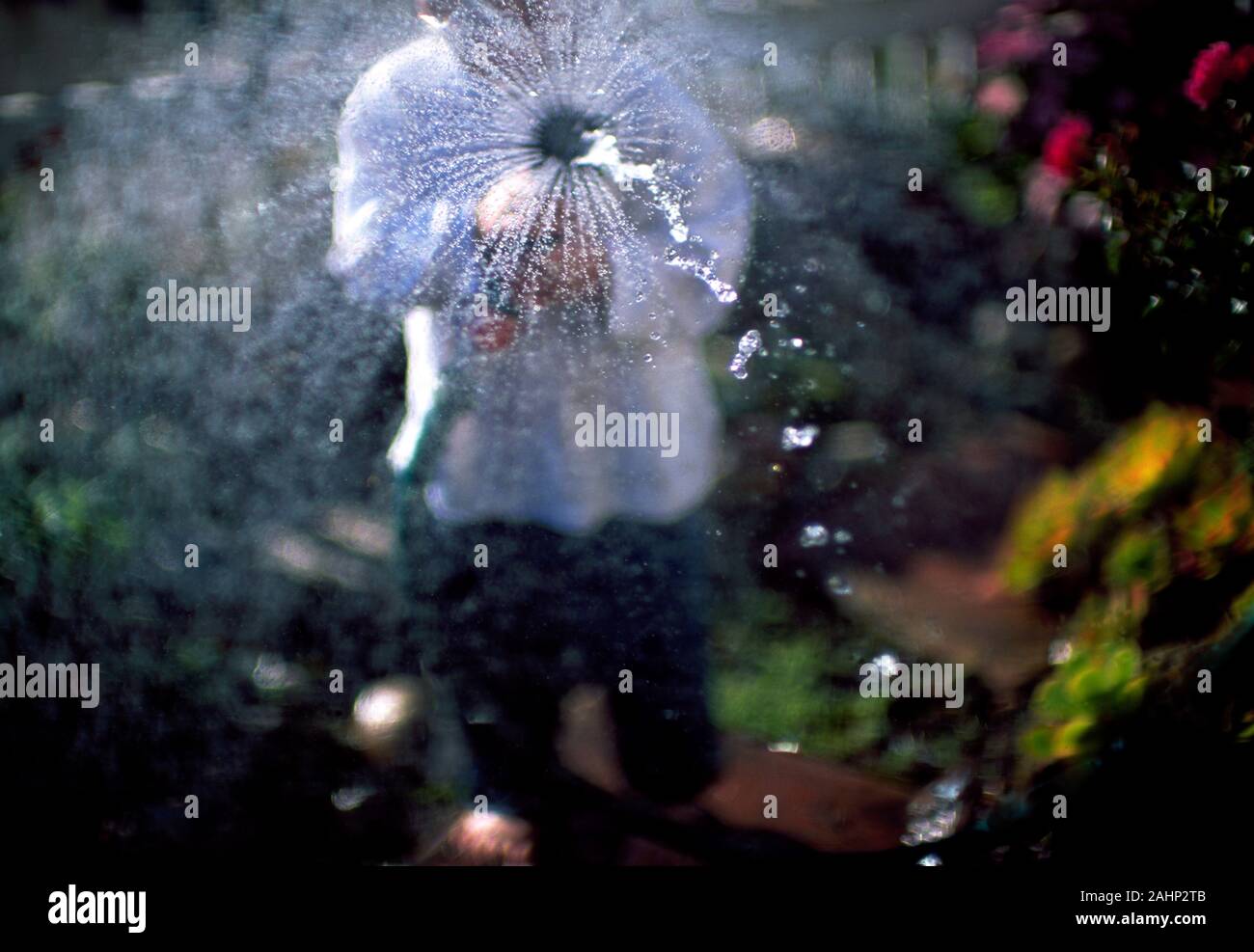 Little boy spraying hose at the camera Stock Photo - Alamy