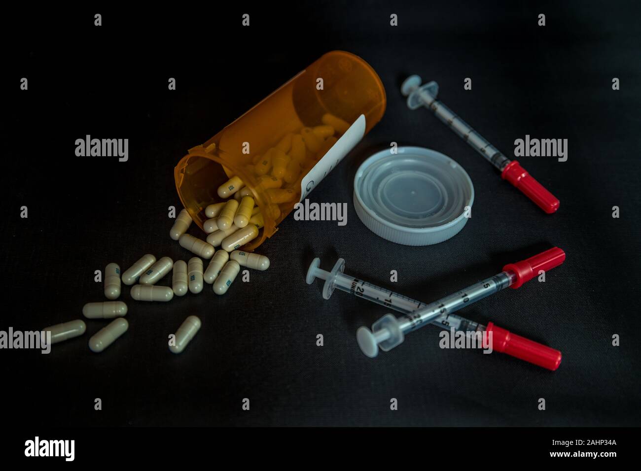 An opened bottle of capsules spilled with the cap alongside and some ...