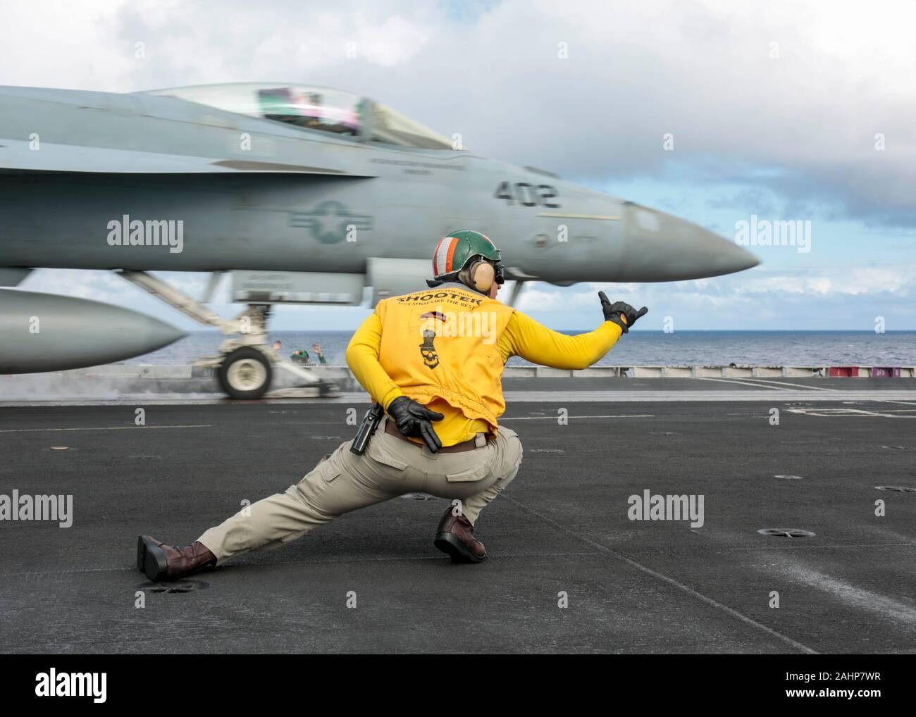 U.S. Navy shooter Lt. Charles Kollar, directs the launch of a F/A-18E ...
