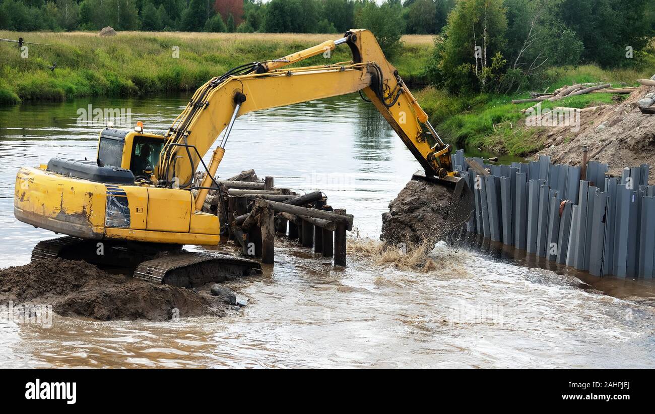 Excavator working in the small forest river, excavator bucket ...