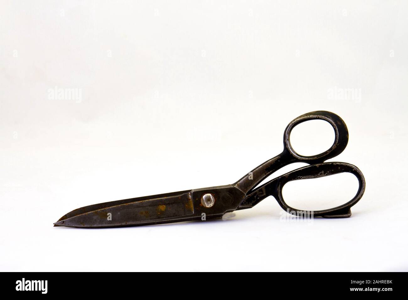 Old and worn pair of large black rusted scissors isolated on a white ...