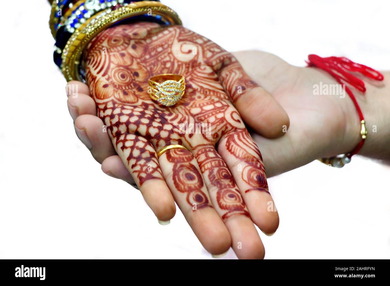 An Indian bride and groom holding their hands with ring during a Hindu ...