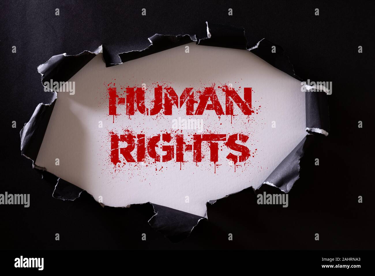 Top view of Black torn paper and the text HUMAN RIGHTS on a white ...