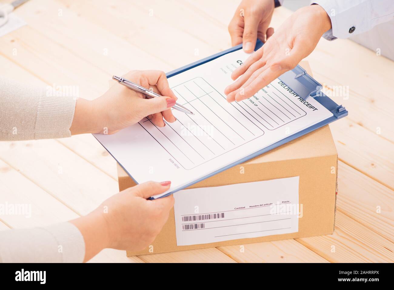 Woman customer signing receipt and receiving the parcel from delivery ...