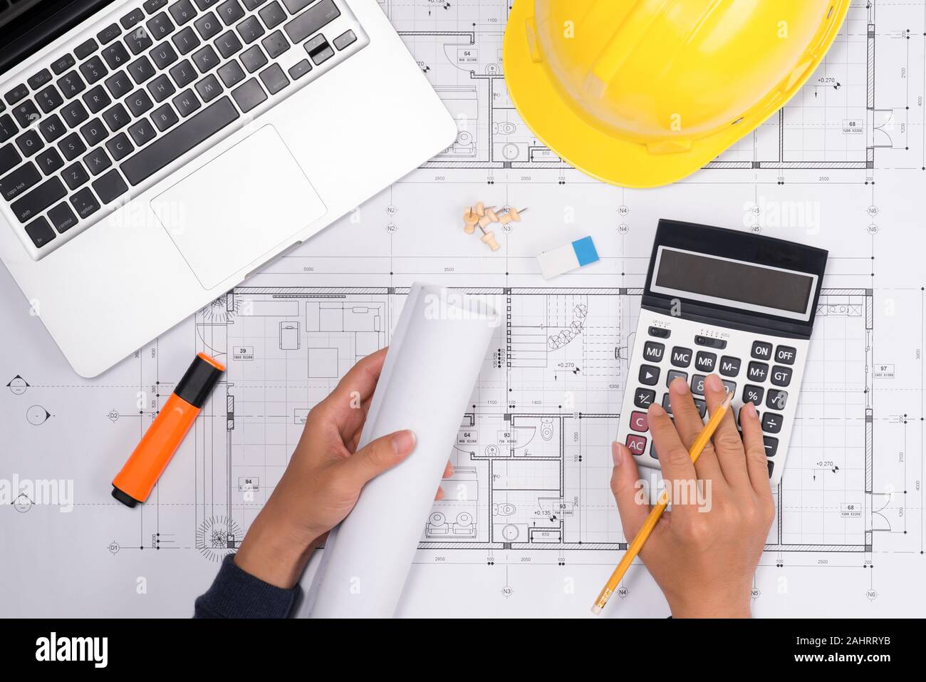 Hand over Construction plans with yellow helmet and drawing tools on ...