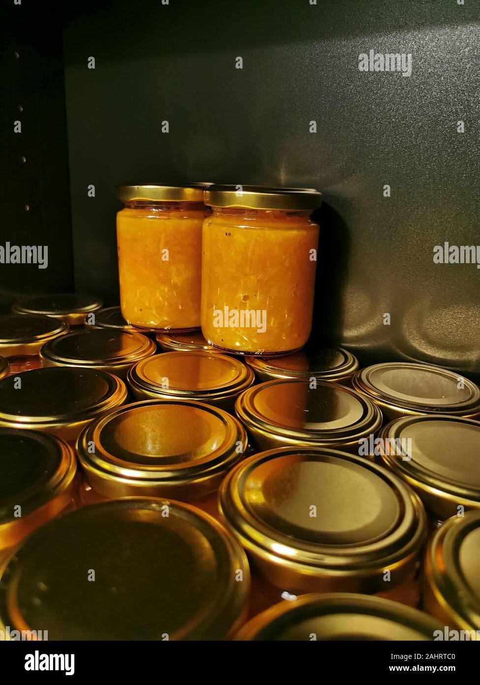 Alignment of blank small glass jars with gold metal caps of homemade ...