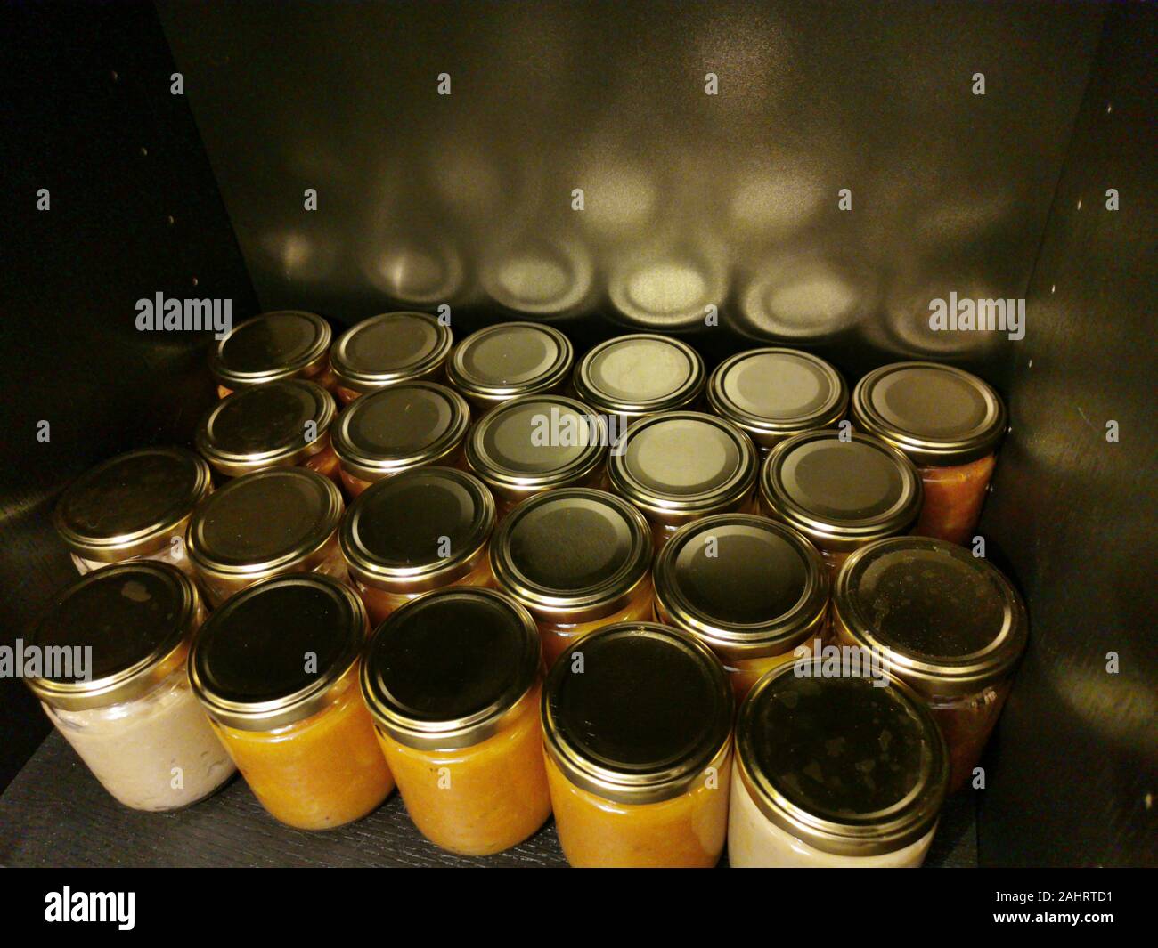 Alignment of blank small glass jars with gold metal caps of homemade ...