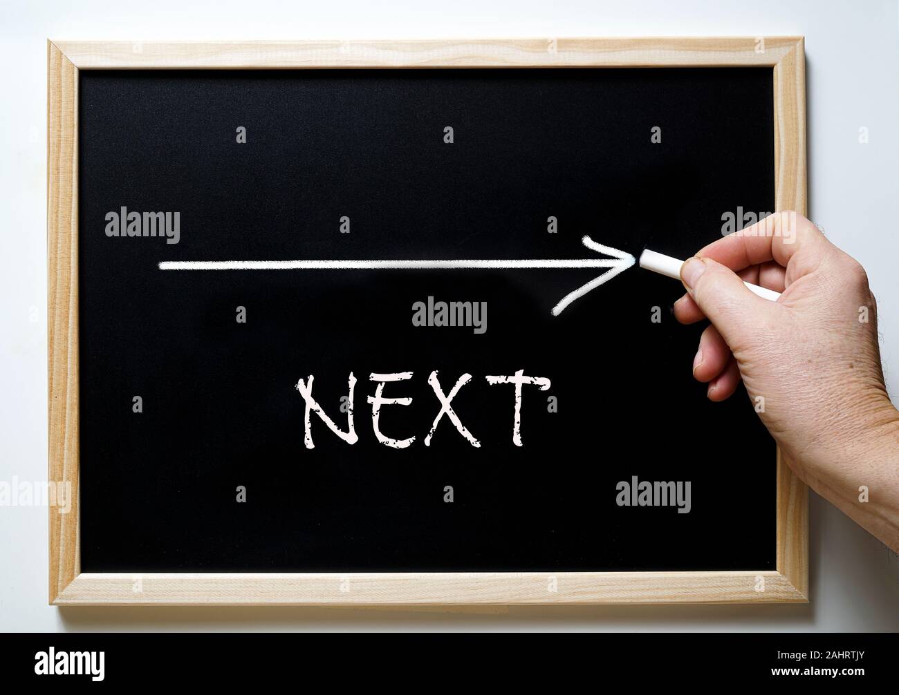 blackboard with writing next and an arrow indicating the right Stock ...