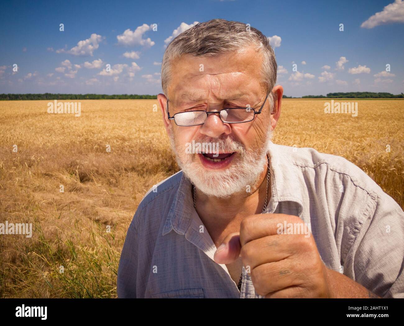 Outdoor portrait of Caucasian senior farmer singing like in karaoke ...