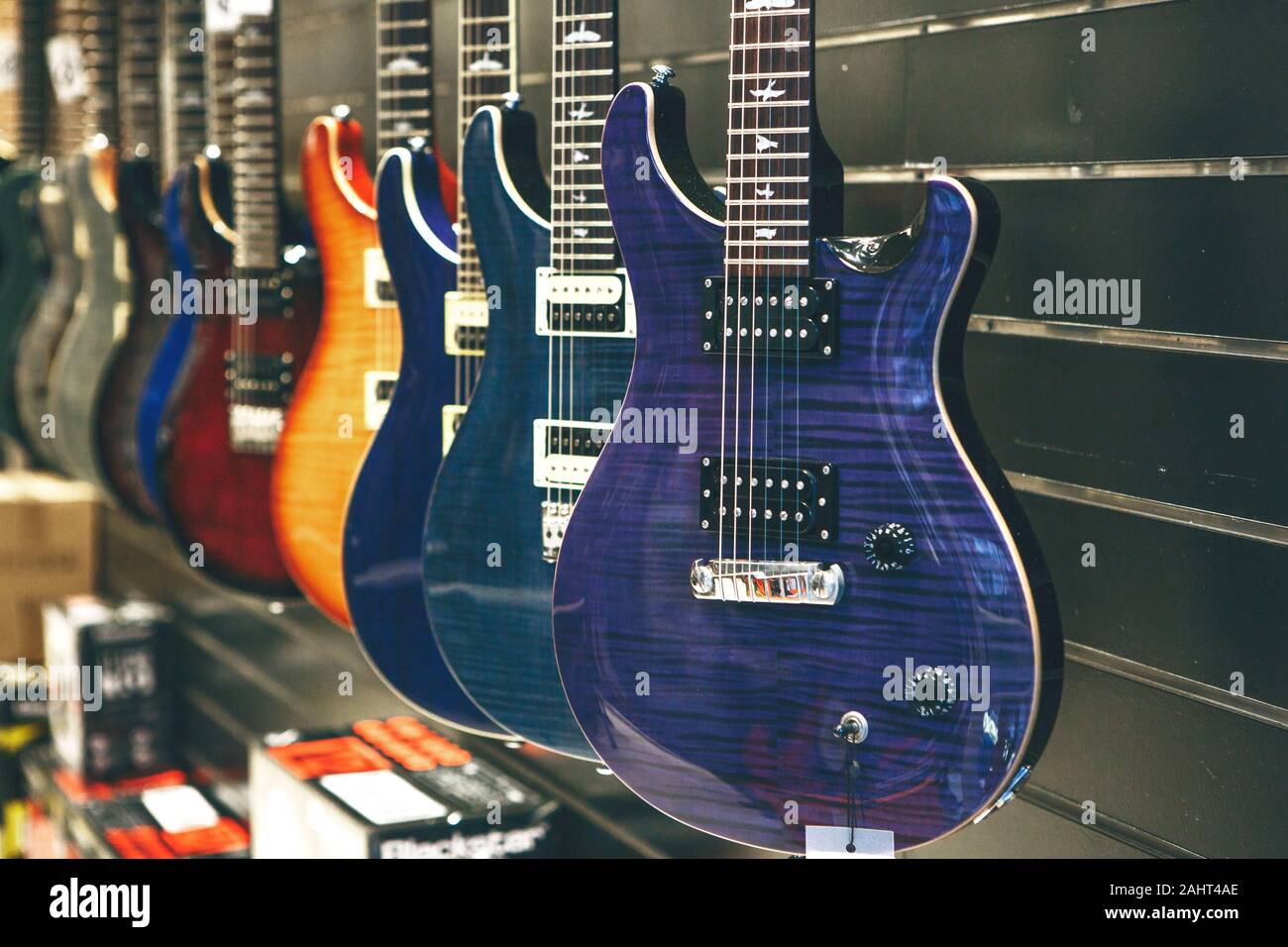 Guitars in a row on a shop window are for sale. Musical instruments ...