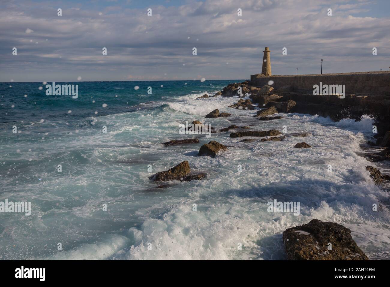 Man standing against the sea on a pier with big wave beating with ...