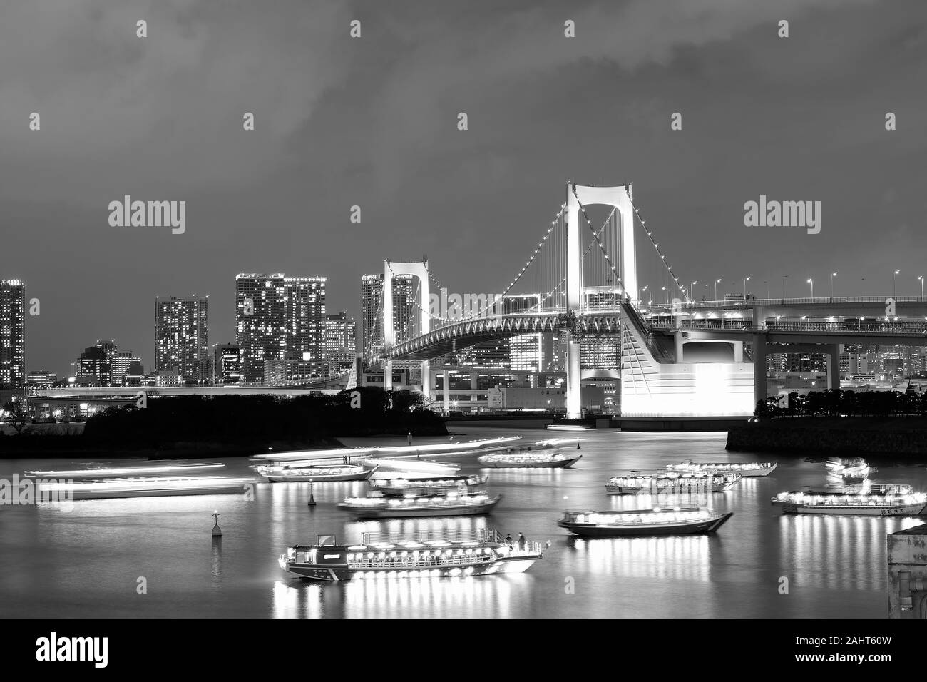 Urban landscape of Tokyo Rainbow bridge with illuminated tourist boats ...