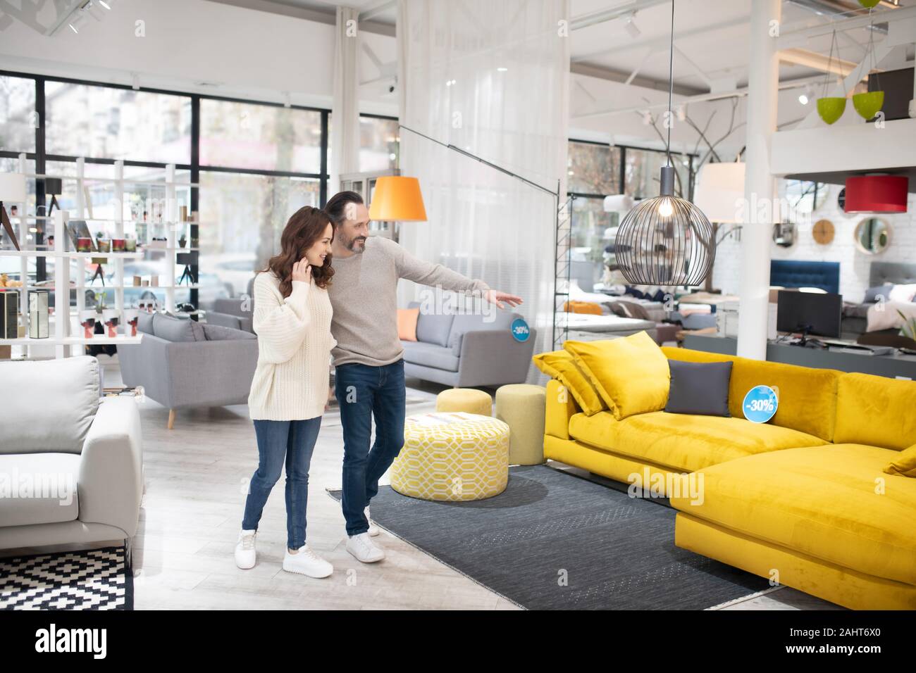 Two people discussing furniture models in a modern furniture shop Stock ...