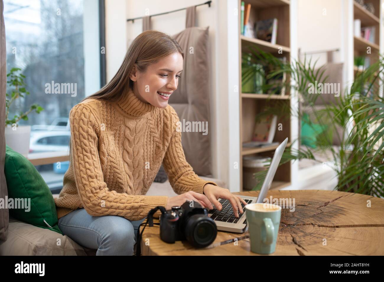 Photographer uploading pictures from the camera on her computer Stock ...
