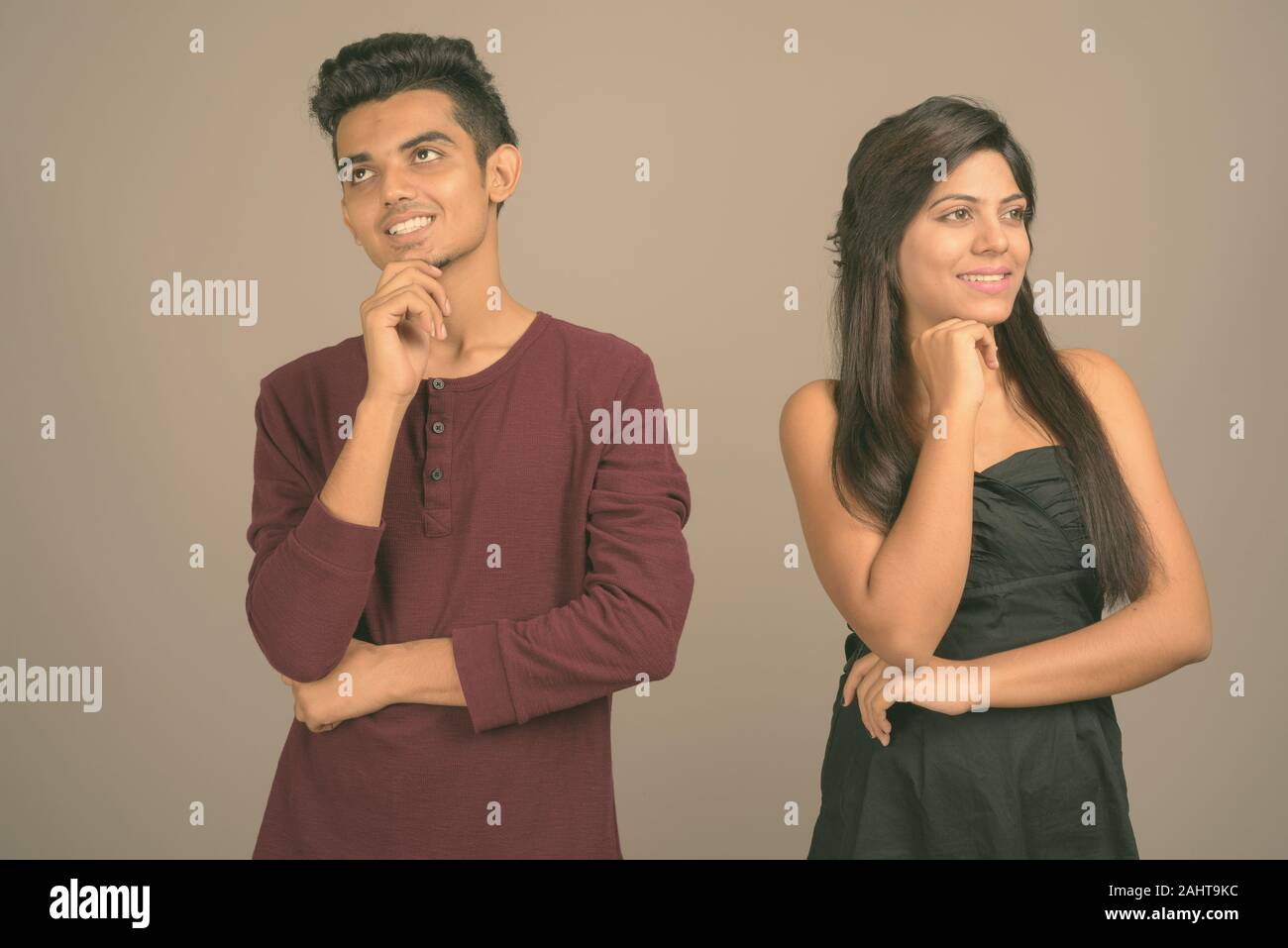 Studio shot of young Indian man and young Indian woman together against ...