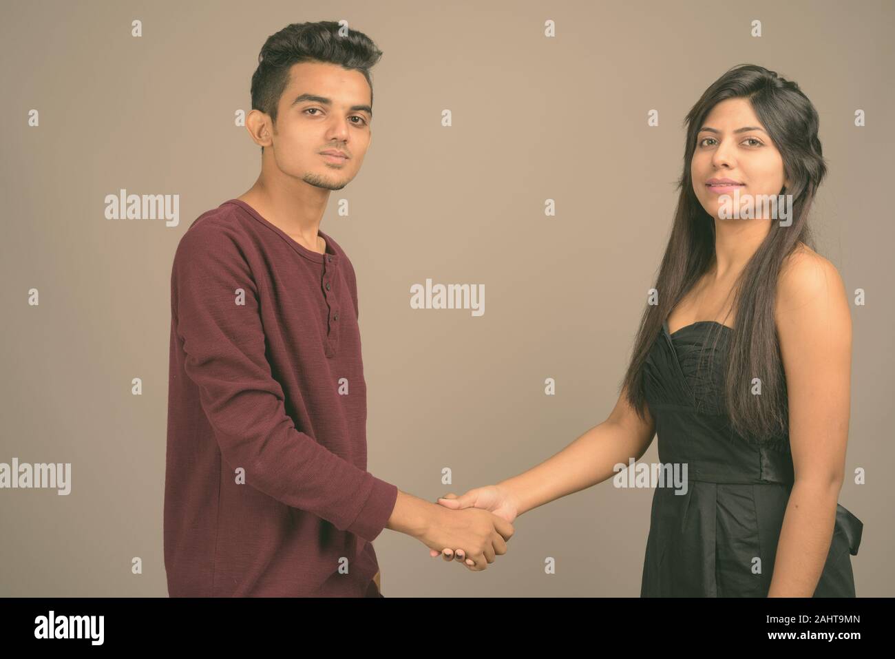 Studio shot of young Indian man and young Indian woman together against ...