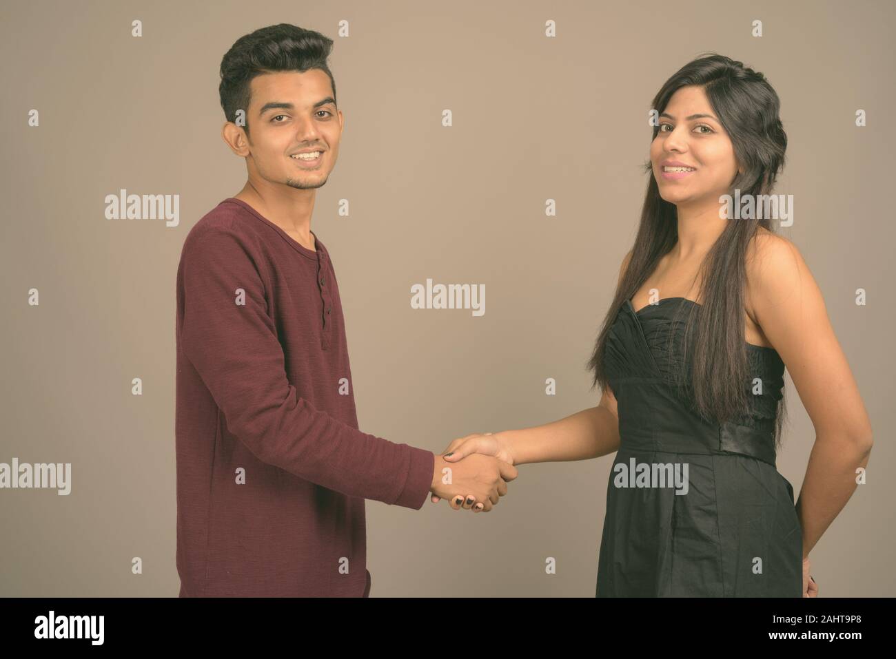 Studio shot of young Indian man and young Indian woman together against ...