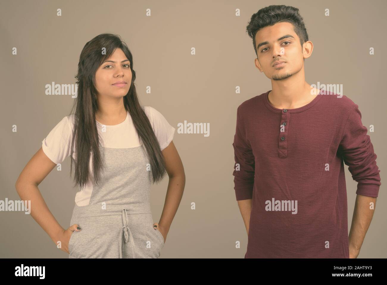 Studio shot of young Indian man and young Indian woman together against ...