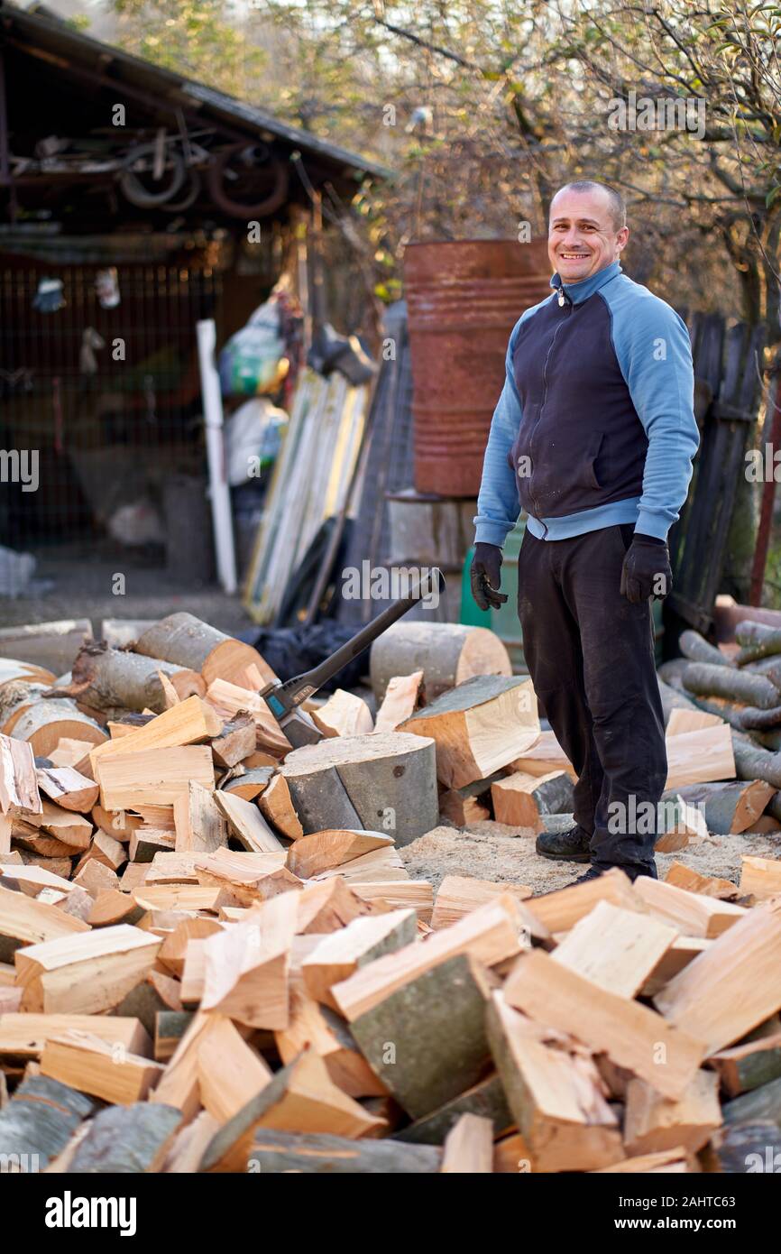 Rural man splitting logs with axe and maul in his backyard Stock Photo ...