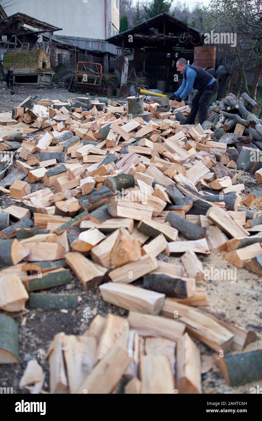 Rural man splitting logs with axe and maul in his backyard Stock Photo ...
