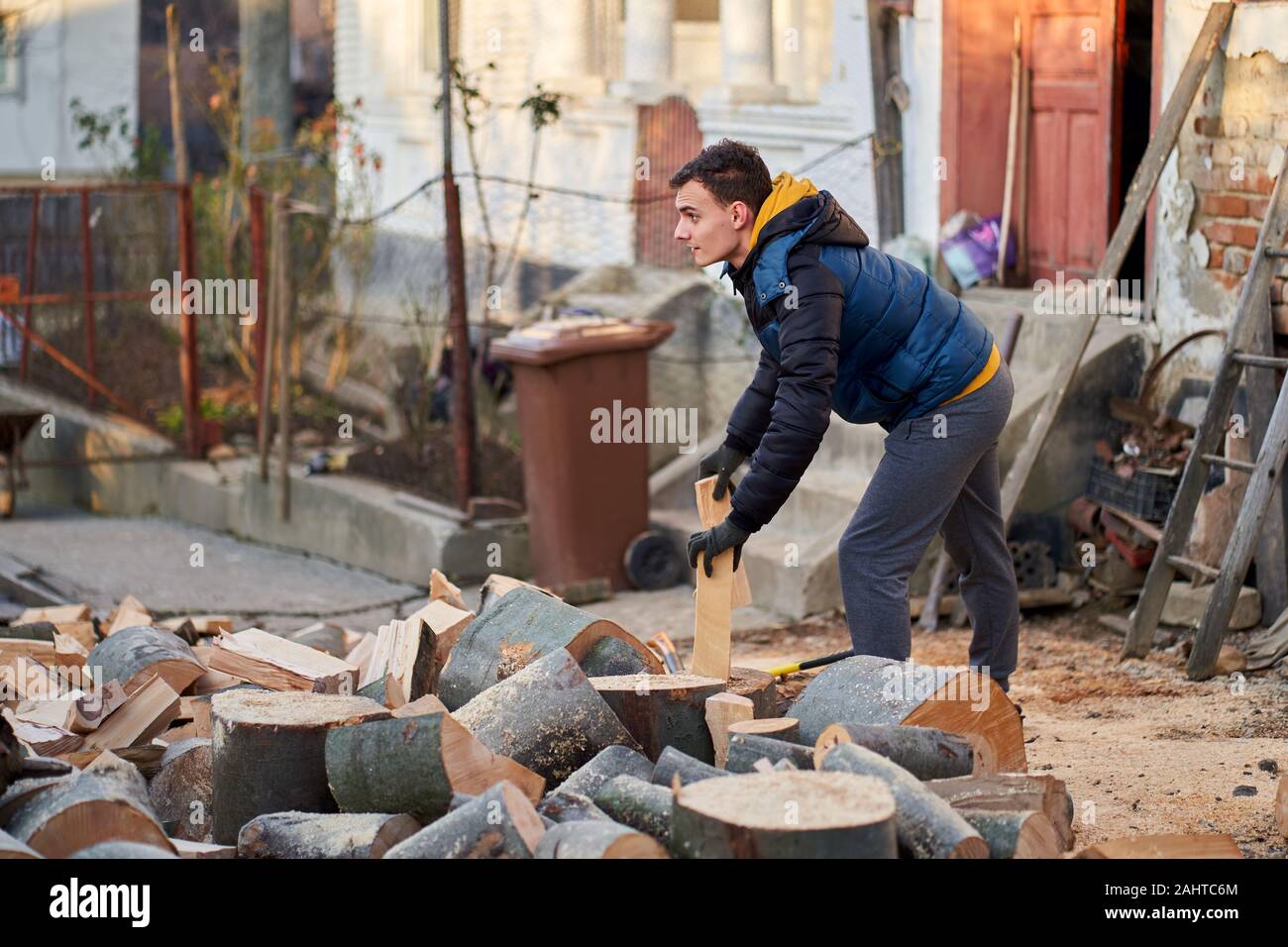 Rural man splitting logs with axe and maul in his backyard Stock Photo ...