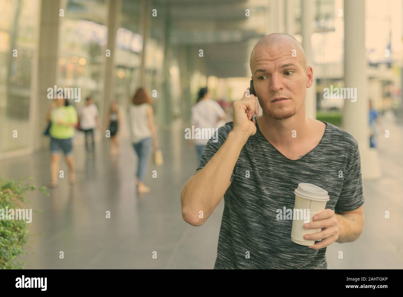 Portrait of young handsome bald man exploring the city of Bangkok Stock ...