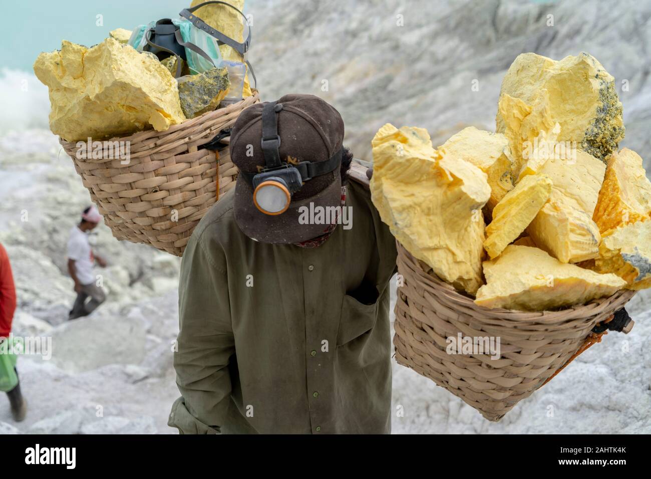 A miner carries sulphur up the crater in the Ijen volcano, Eastern Java ...