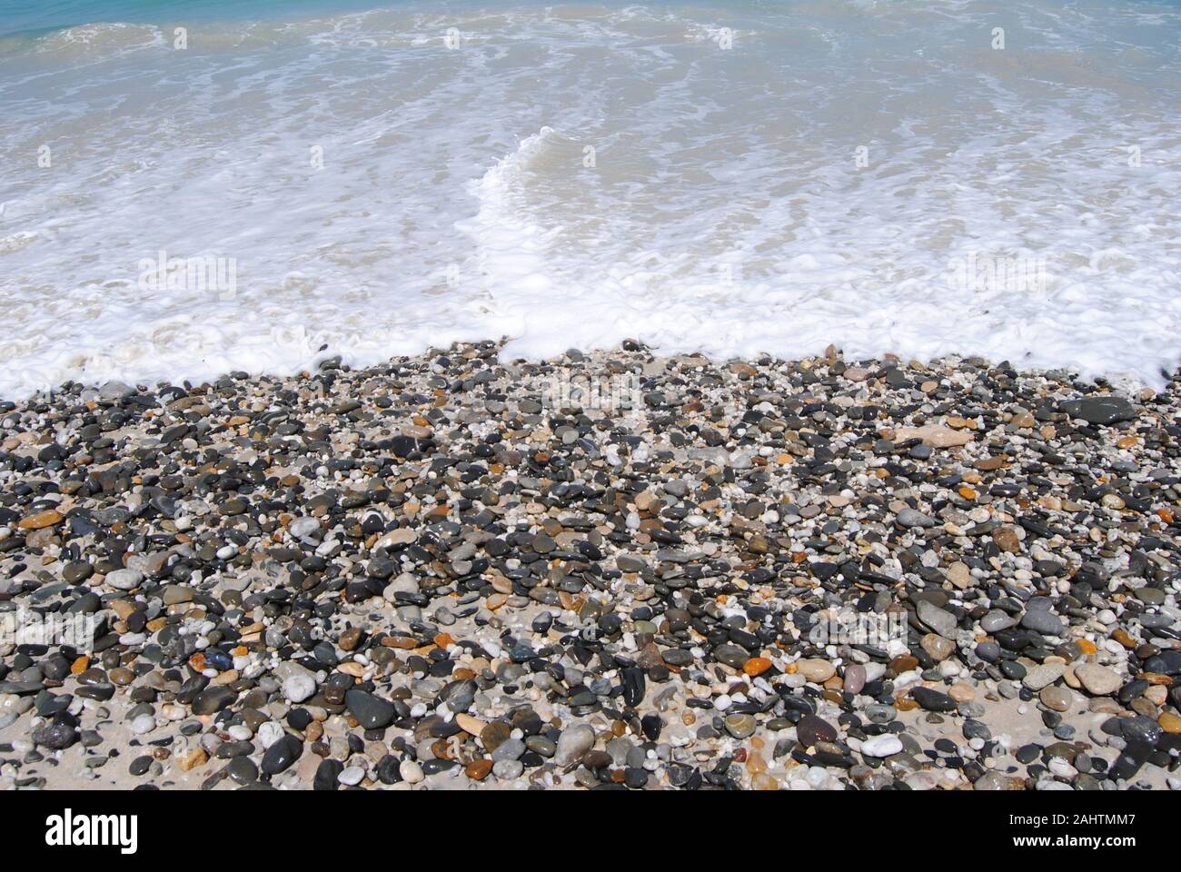 Ocean Washing Over Multi-Color Beach Pebbles Stock Photo - Alamy