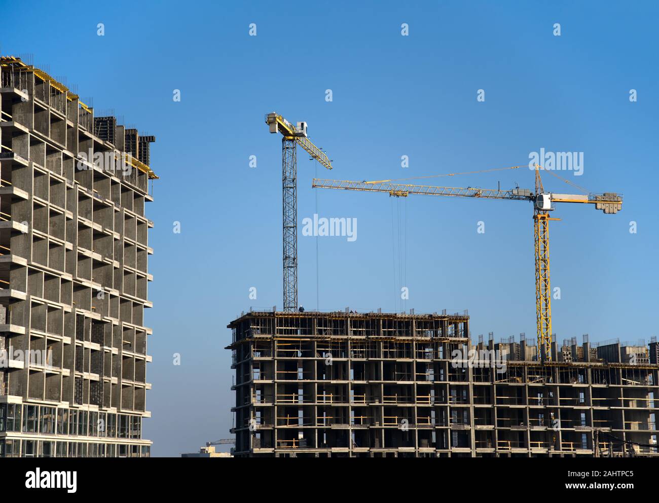 Hydraulic luffing jib tower cranes and workers being poured concrete ...