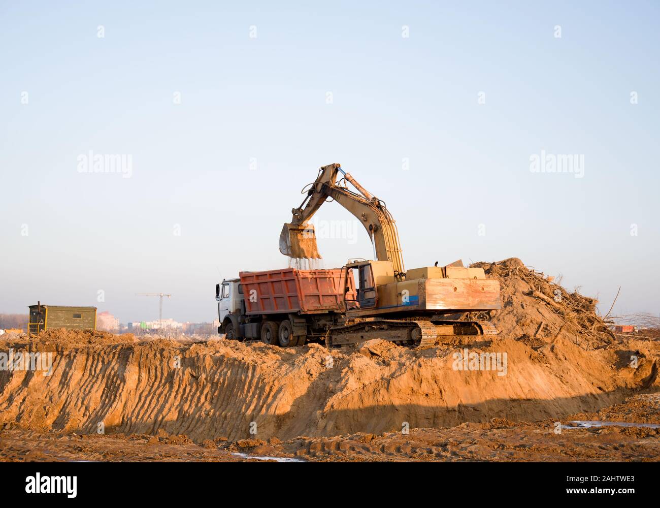 Excavator load the sand to the dump truck on construction site. Backhoe ...