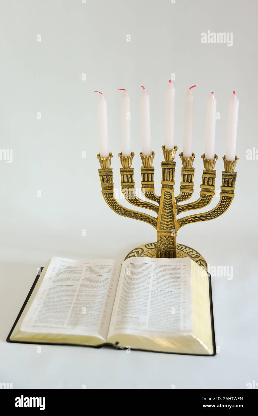 Menorah and open bible with 7 unlit candles isolated on white ...