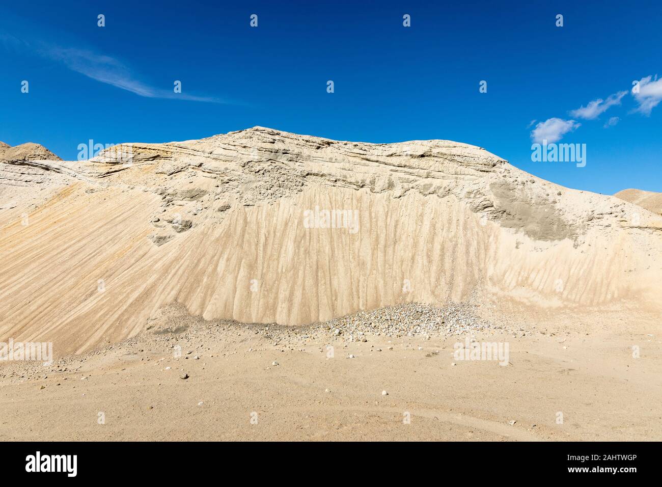 Sand in a big sand pit, with blue sky and white clouds in the ...