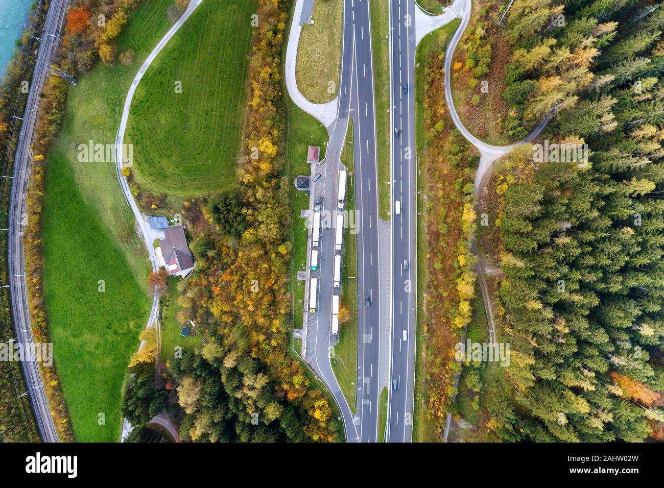 Top dawn aerial view of freeway speed road between yellow autumn forest trees in rural area ...