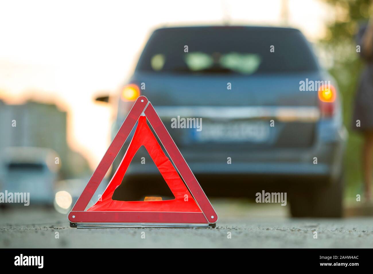Red emergency triangle stop sign and broken car on a city street Stock ...