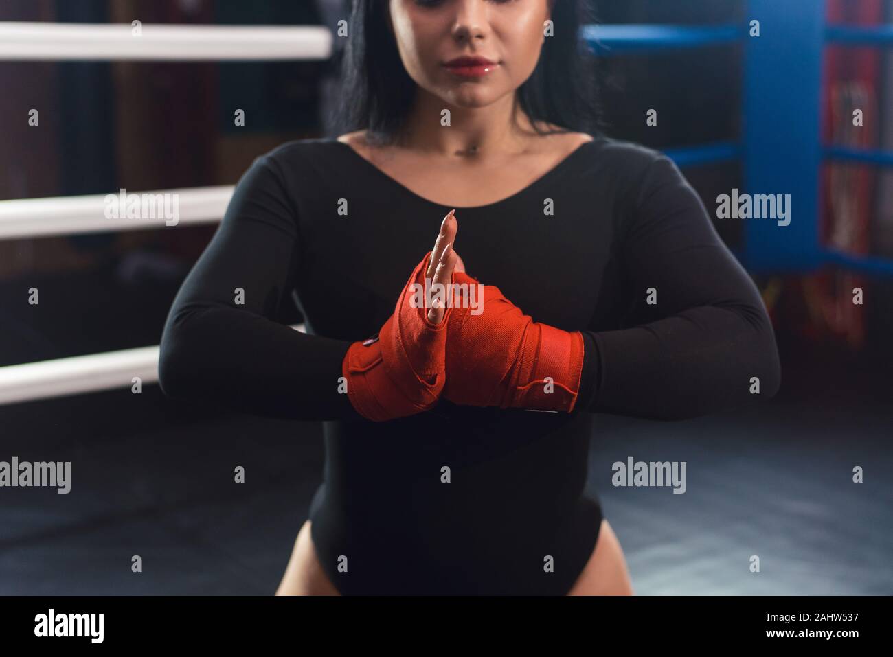 Boxer woman hands with red boxing wraps in the boxing ring. Close-up ...