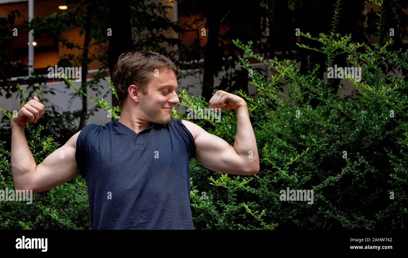 A handsome young man flexing his muscles Stock Photo - Alamy