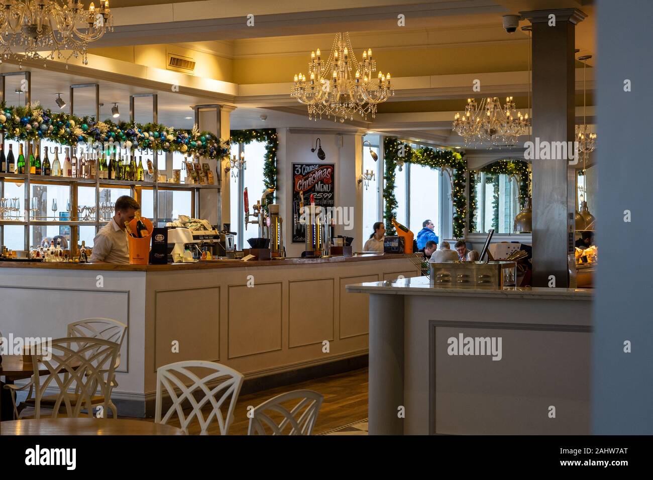 The interior of a restaurant with a barman at the bar serving drinks ...