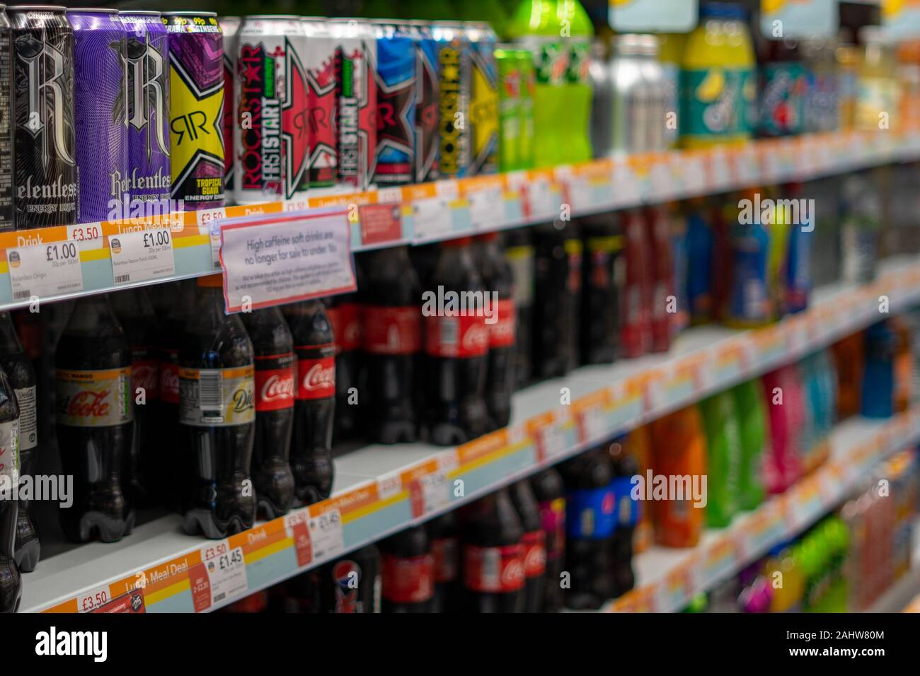 Energy drinks on a shelf in a supermarket surrounded by other soft ...