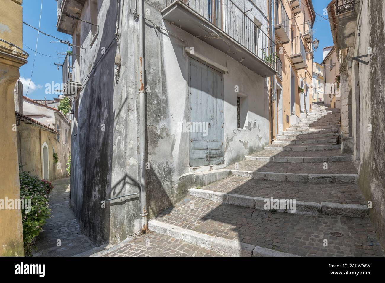cityscape of old uphill village with tall buildings on narrow stairway ...