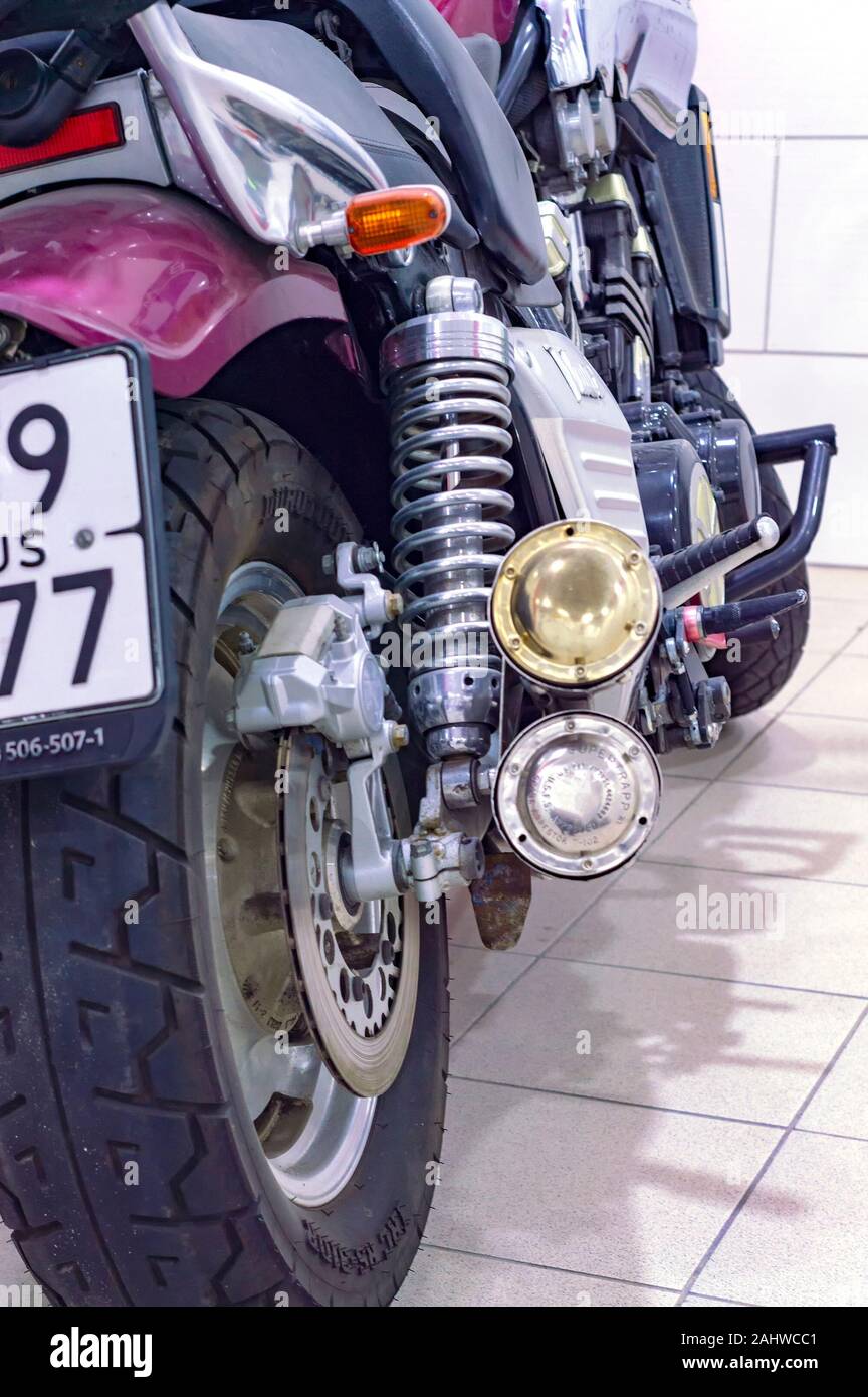 Burgundy color motorcycle in garage - fragment. Back view. Surgut ...
