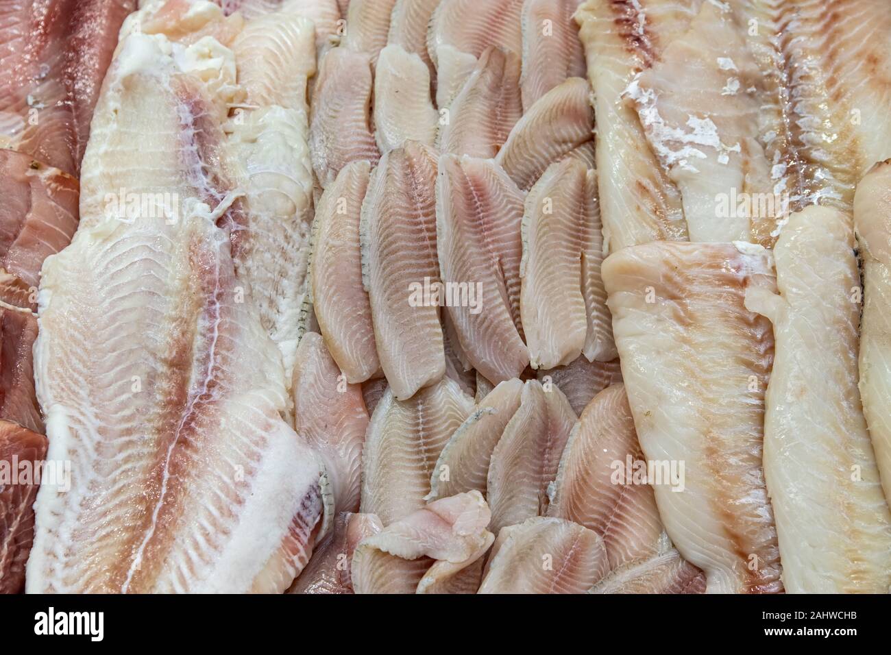 Different types of fresh fish on ice in supermarket, top view. Close up ...