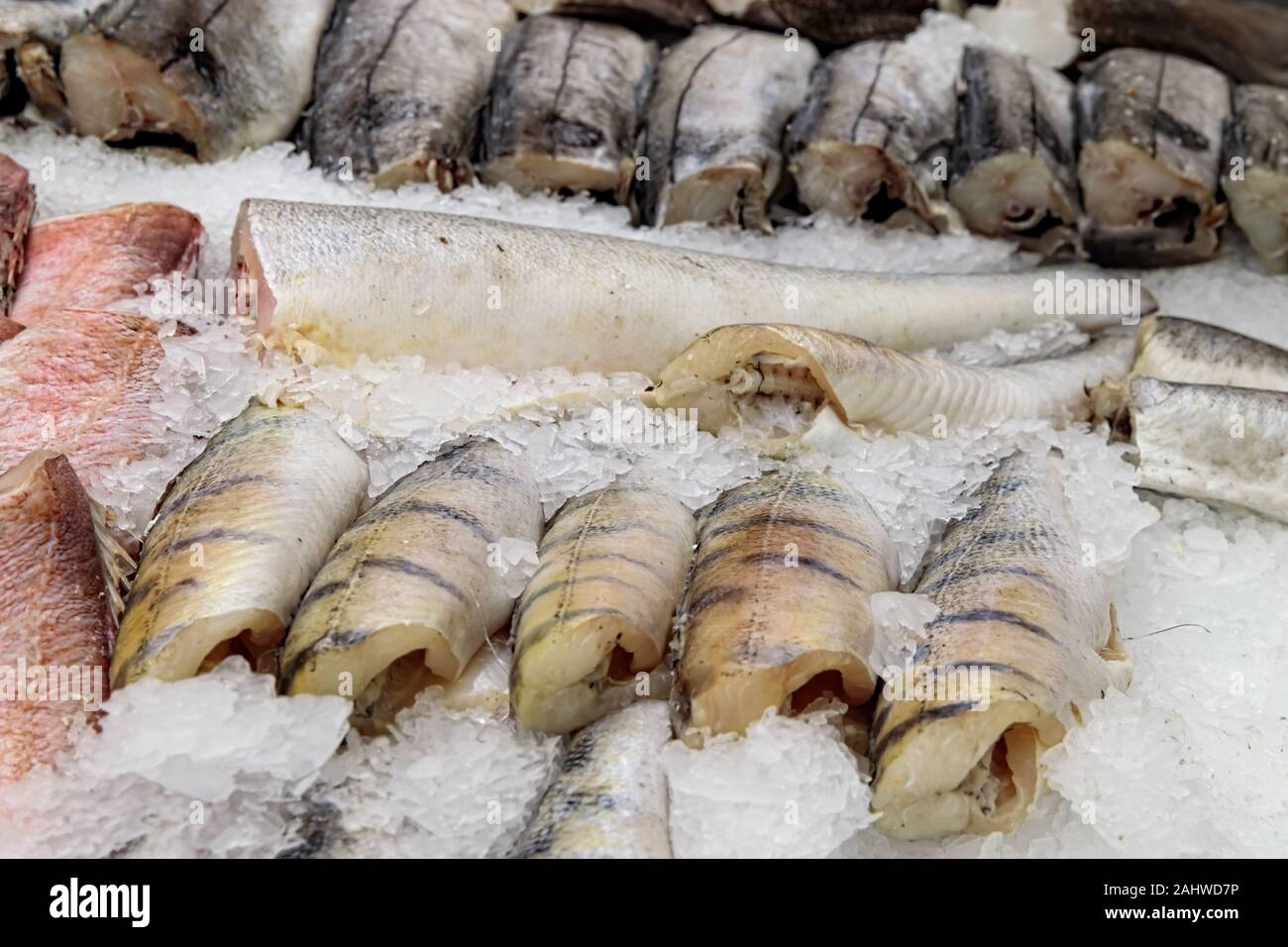 Different types of fresh fish on ice in supermarket, top view. Close up ...